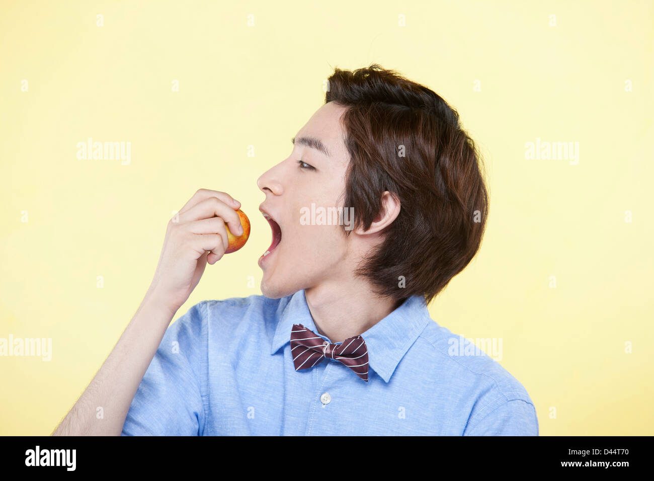 close up shot of a man trying bite an apple Stock Photo - Alamy