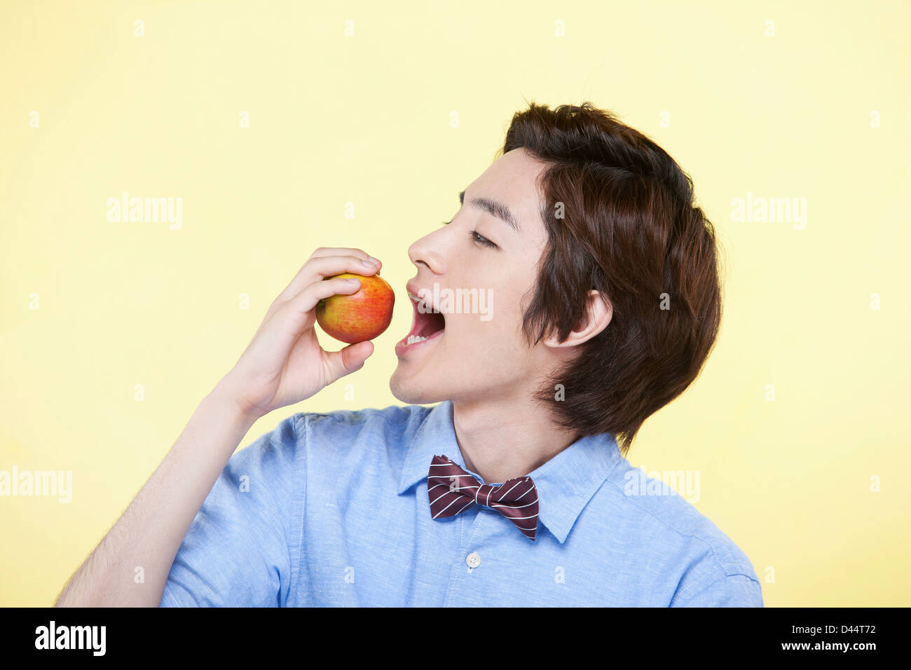 close up shot of a man trying bite an apple Stock Photo - Alamy