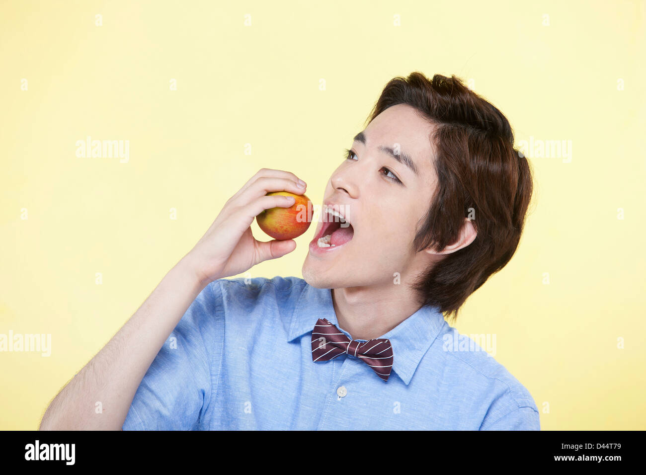 close up shot of a man trying bite an apple Stock Photo - Alamy