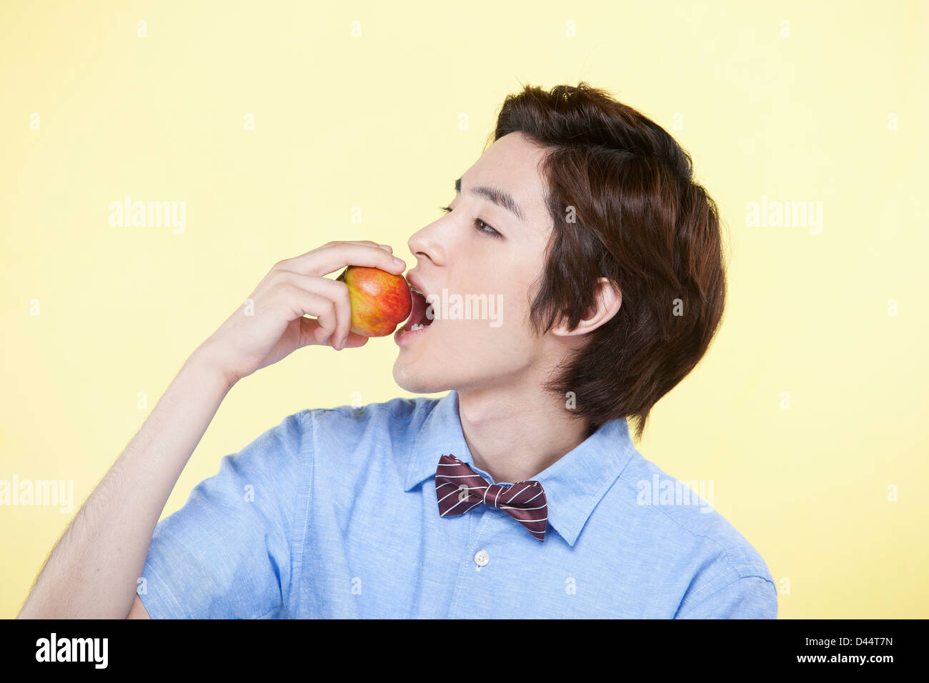 close up shot of a man trying bite an apple Stock Photo - Alamy
