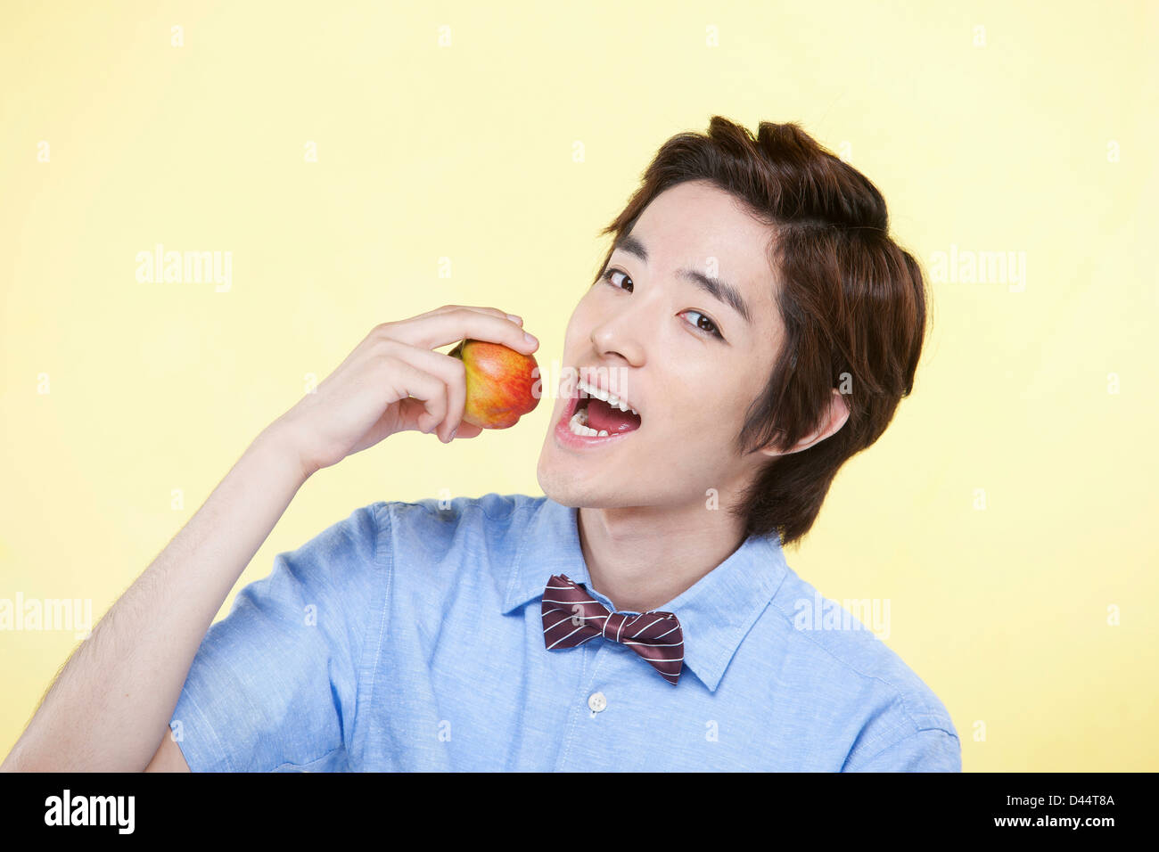close up shot of a man trying bite an apple Stock Photo - Alamy