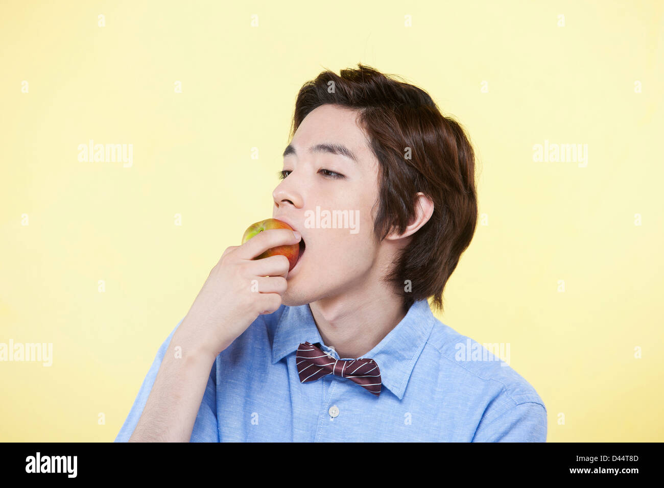 close up shot of a man trying bite an apple Stock Photo - Alamy