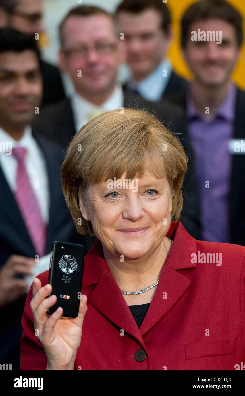 German Chancellor Angela Merkel presents a tap-proof mobile phone of ...