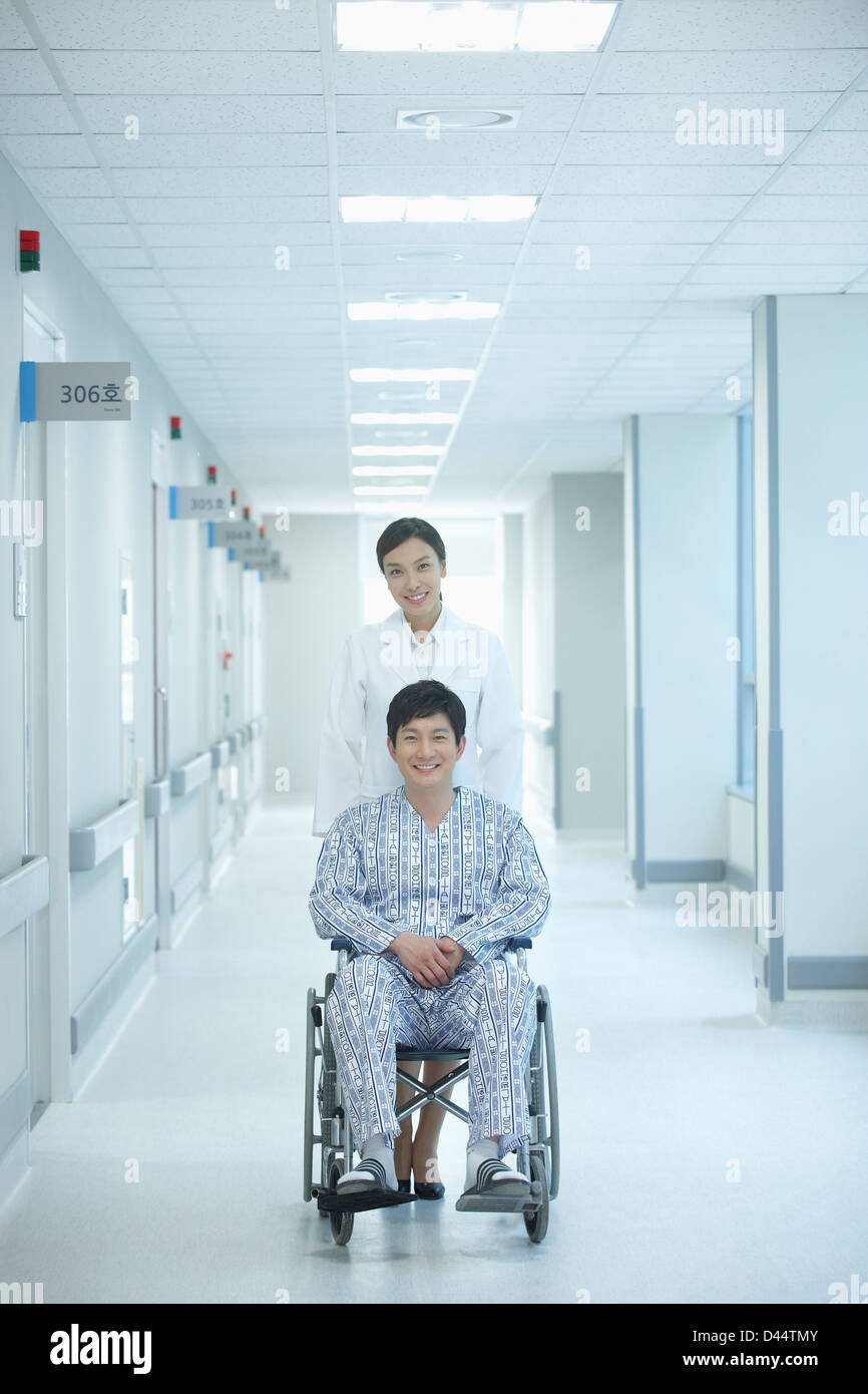 a doctor behind a man in a wheelchair Stock Photo - Alamy