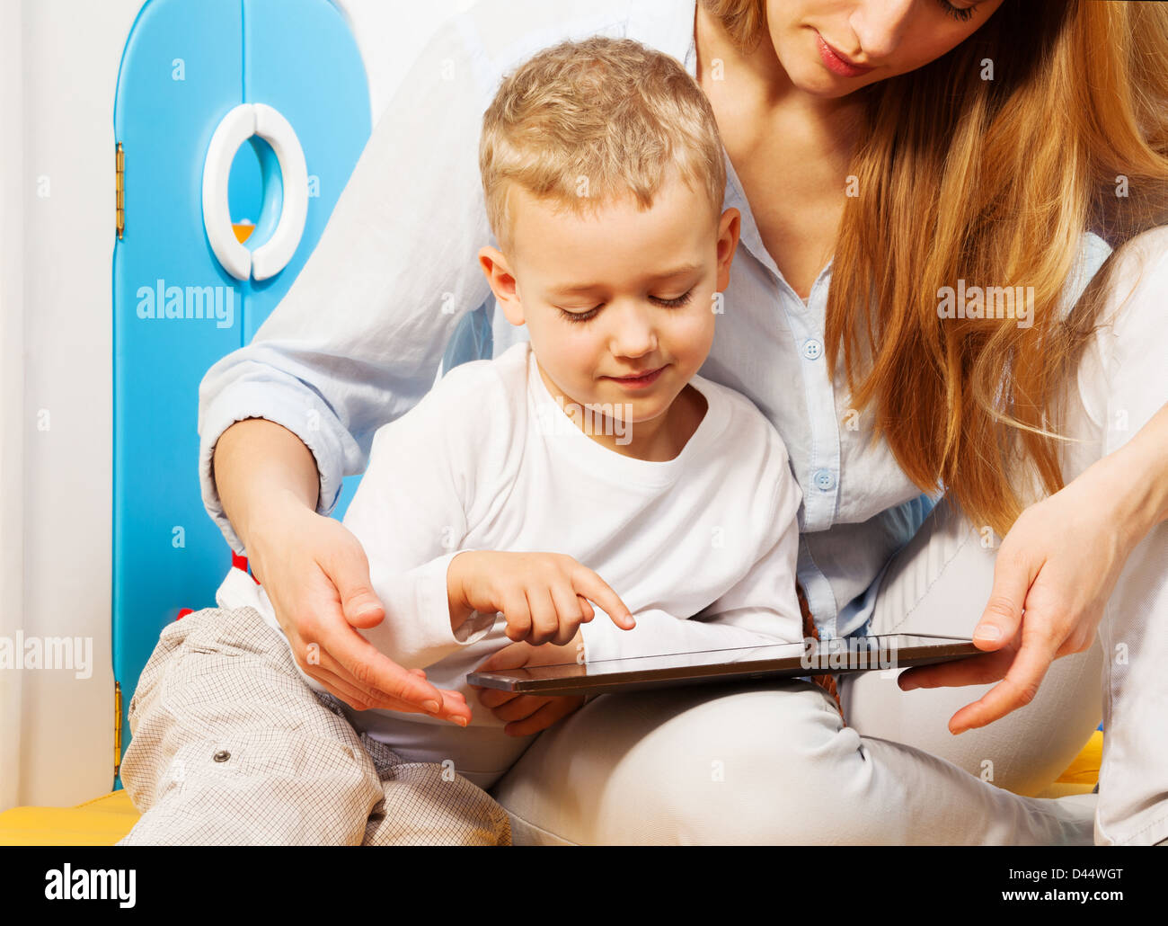 Tablet computer and kids - mom showing son how to use touch interface ...
