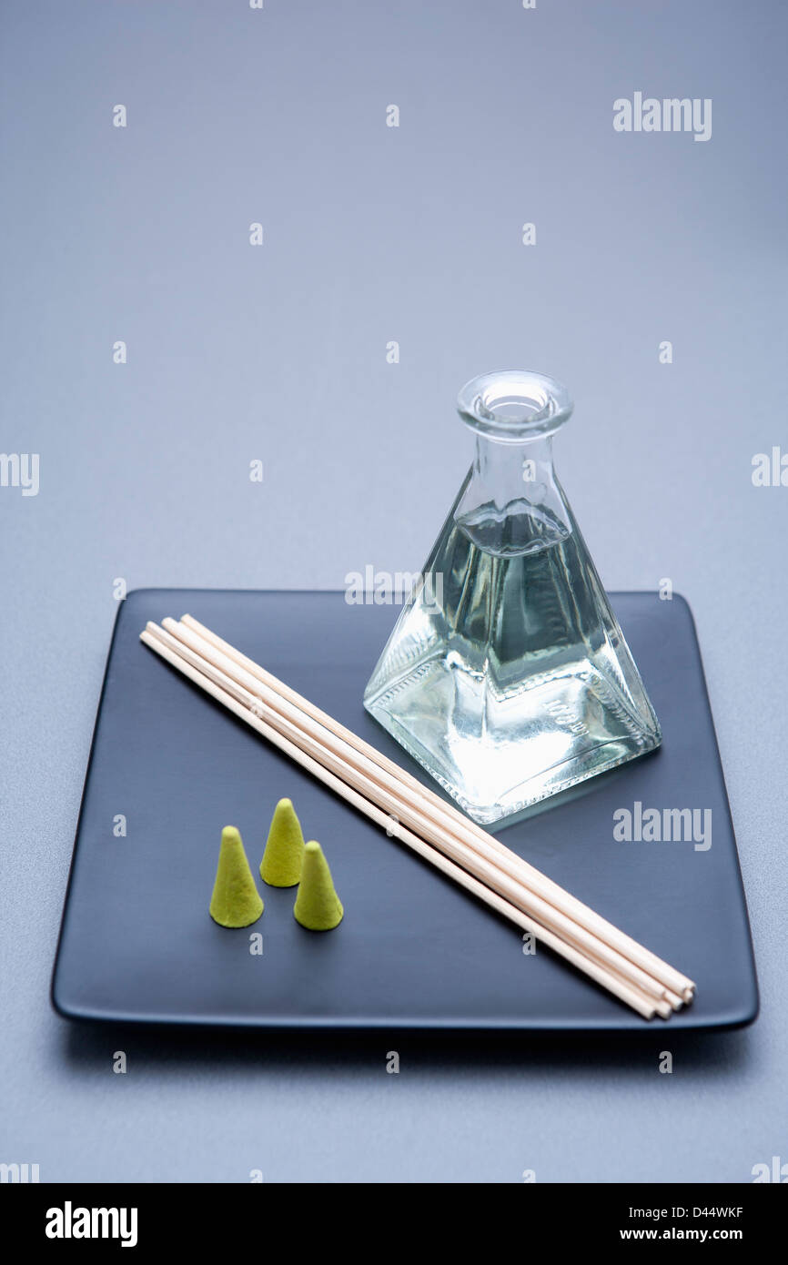 a bottle with liquid next to incense Stock Photo - Alamy