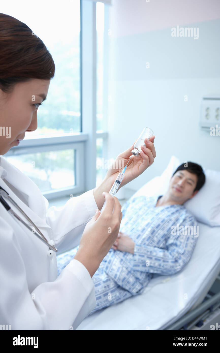 doctor getting ready to give an injection to a patient in the room ...