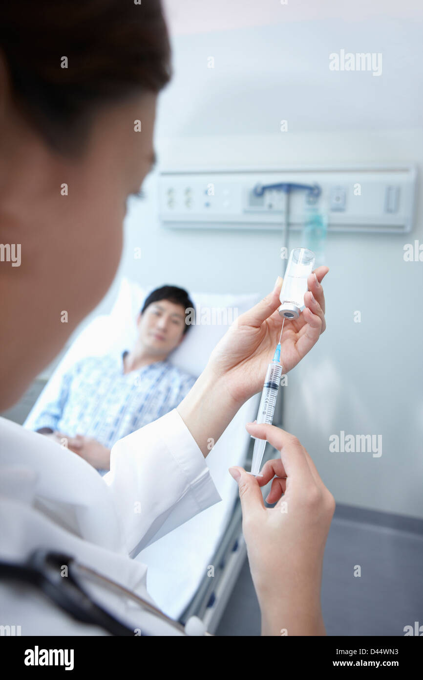 doctor getting ready to give an injection to a patient in the room ...