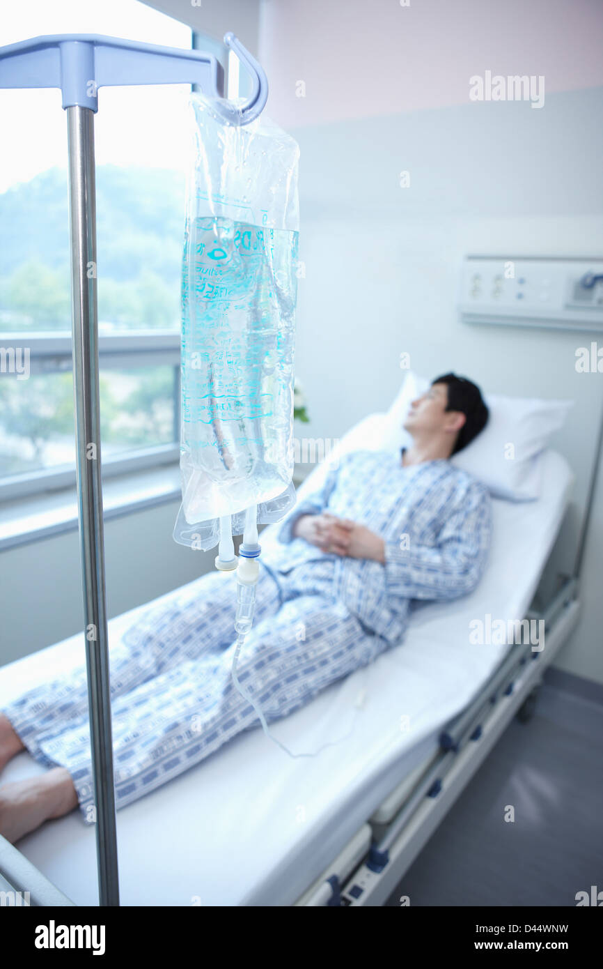 a patient lying on the bed with a iv drop Stock Photo - Alamy