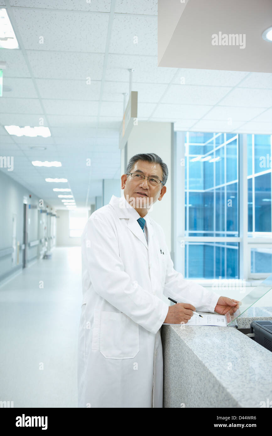 a doctor reviewing the papers in hospital corridor Stock Photo - Alamy