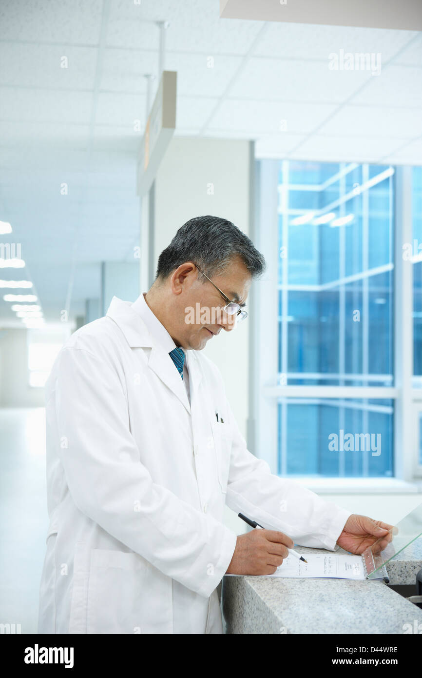 a doctor reviewing the papers in hospital corridor Stock Photo - Alamy