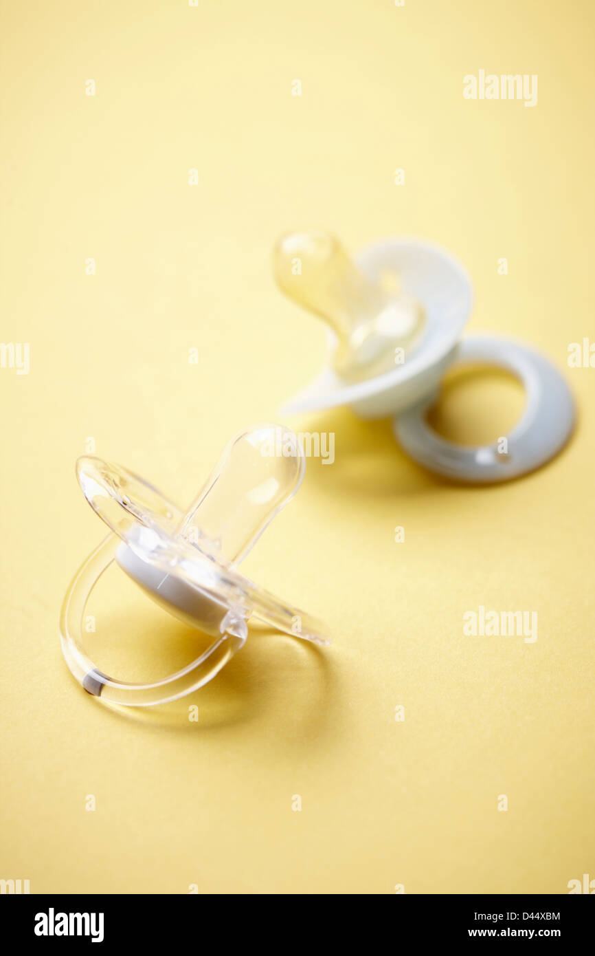 baby's pacifier on yellow background Stock Photo - Alamy