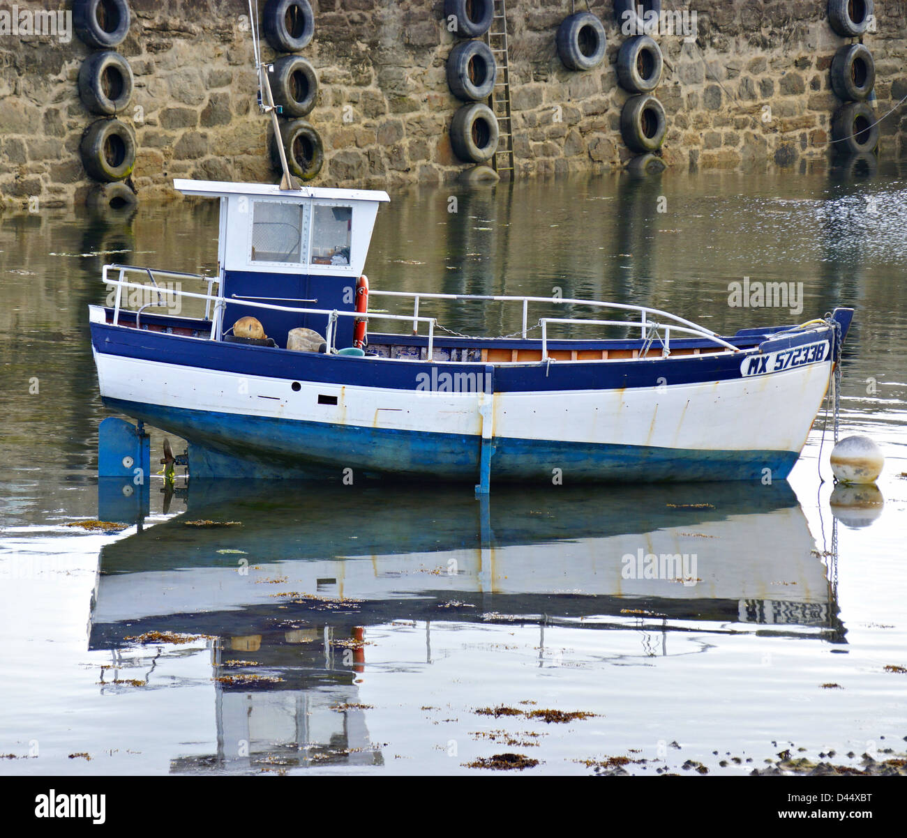 Small fishing boat with reflection in the water Stock Photo - Alamy