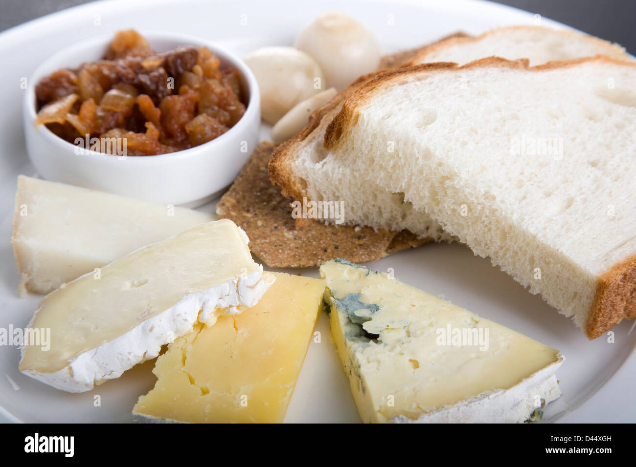 Ploughmans platter with pickle, white bread, pickled onions and ...