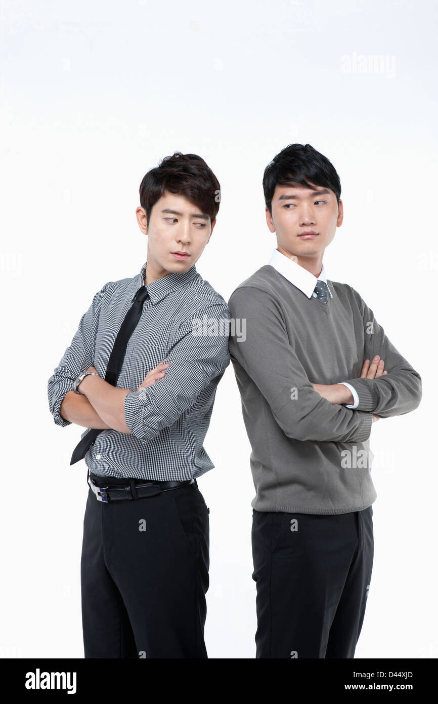 two businessmen standing against each other's shoulder with arms ...