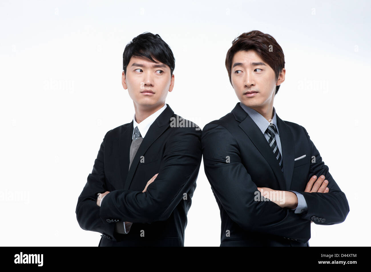 two businessmen standing against each other's shoulder with arms ...