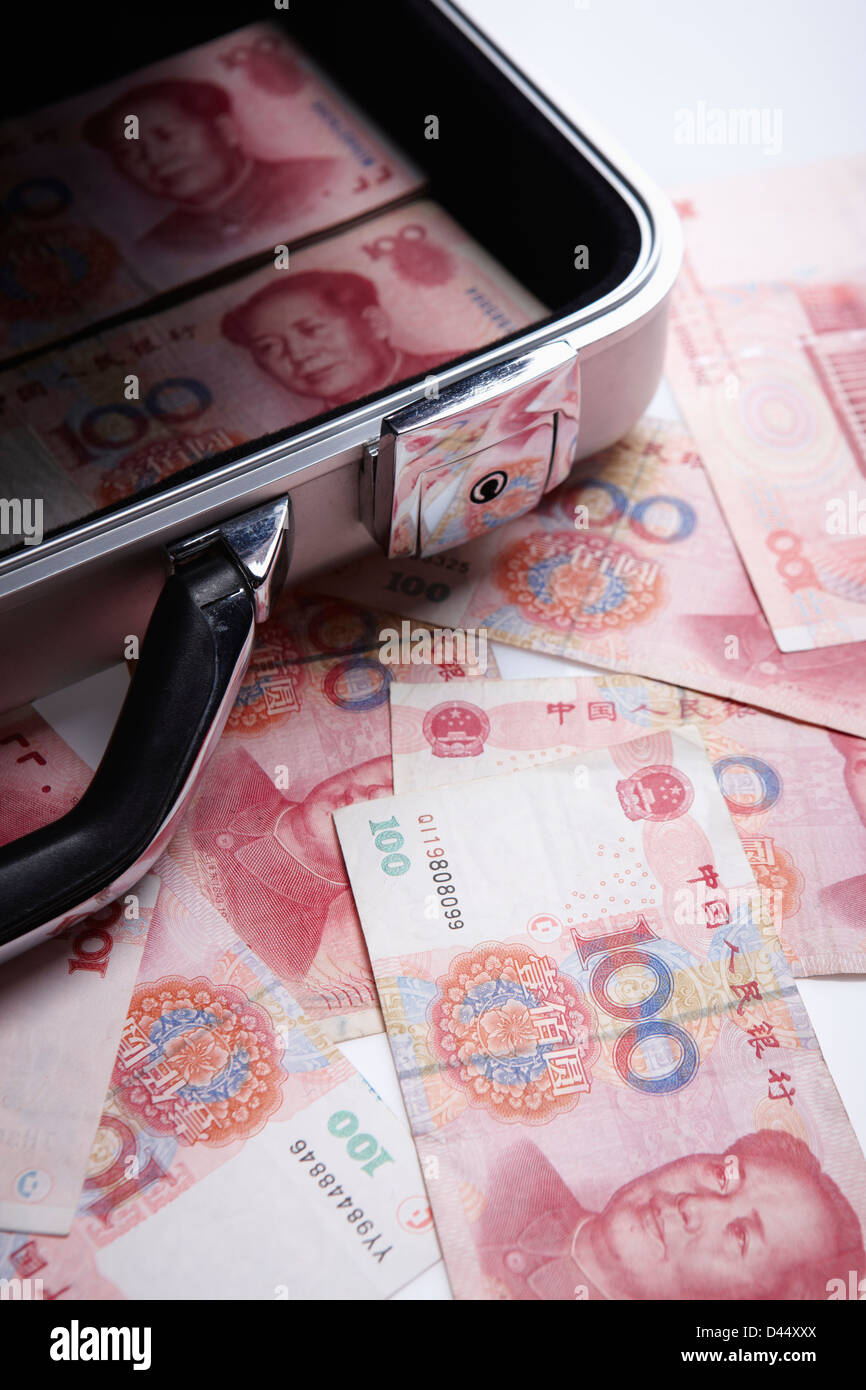 a suitcase on Chinese money filled with Chinese money Stock Photo - Alamy