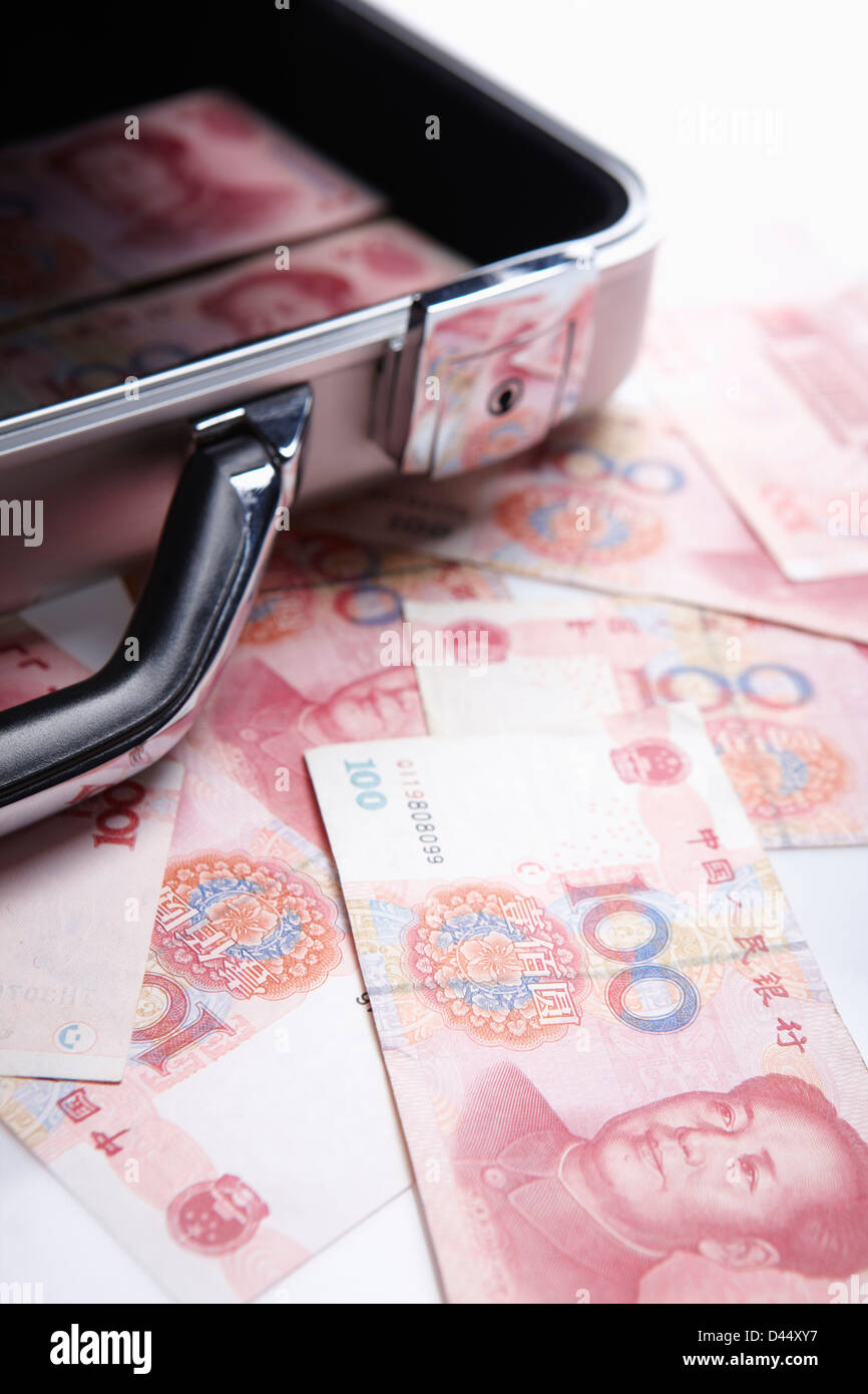 a suitcase on Chinese money filled with Chinese money Stock Photo - Alamy