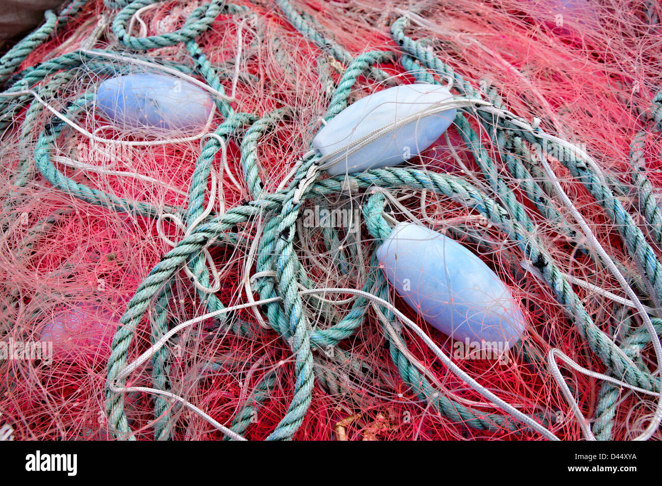 Heap of red fishing nets with ropes and floats Stock Photo - Alamy