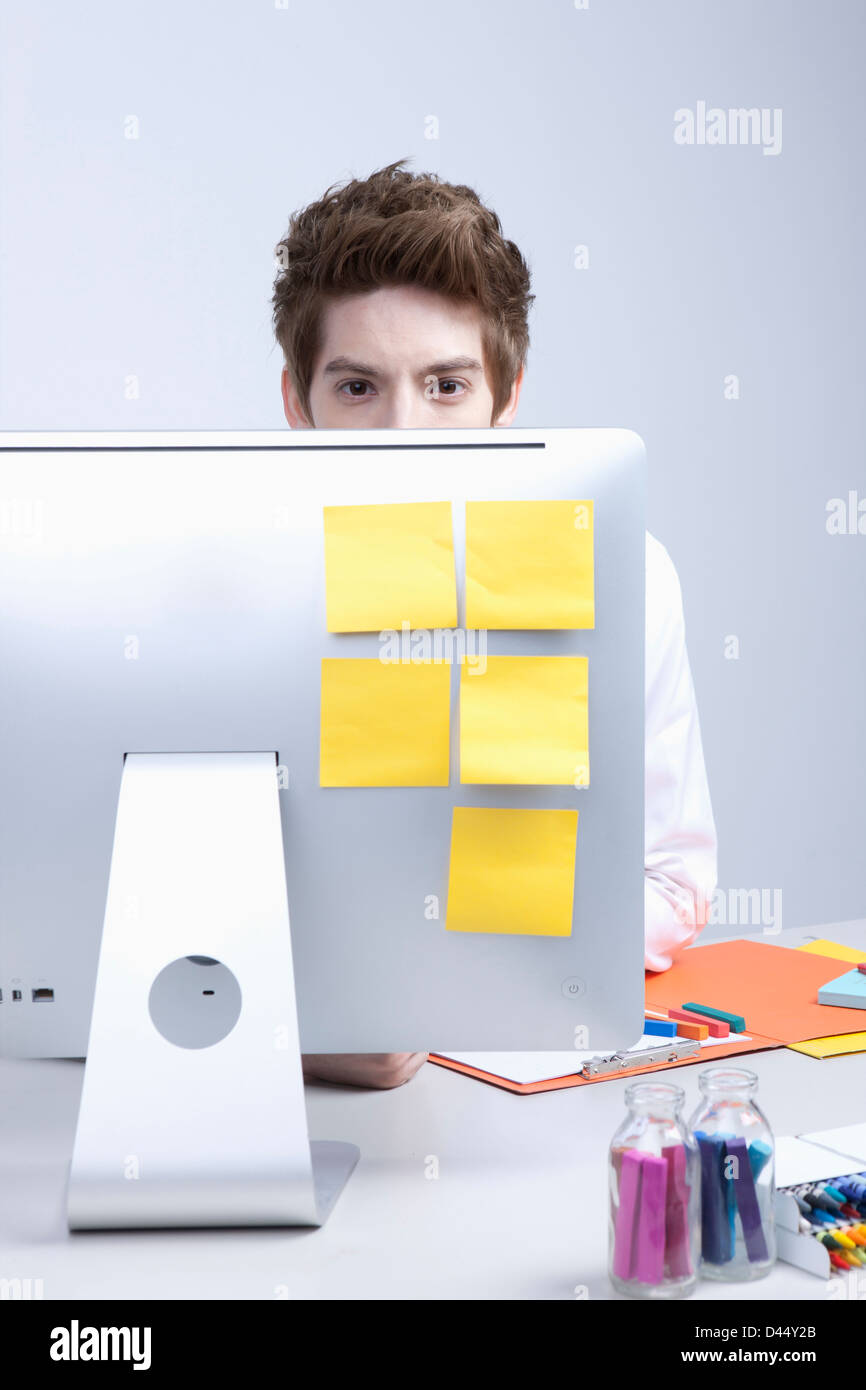 a man behind a computer on a desk Stock Photo - Alamy