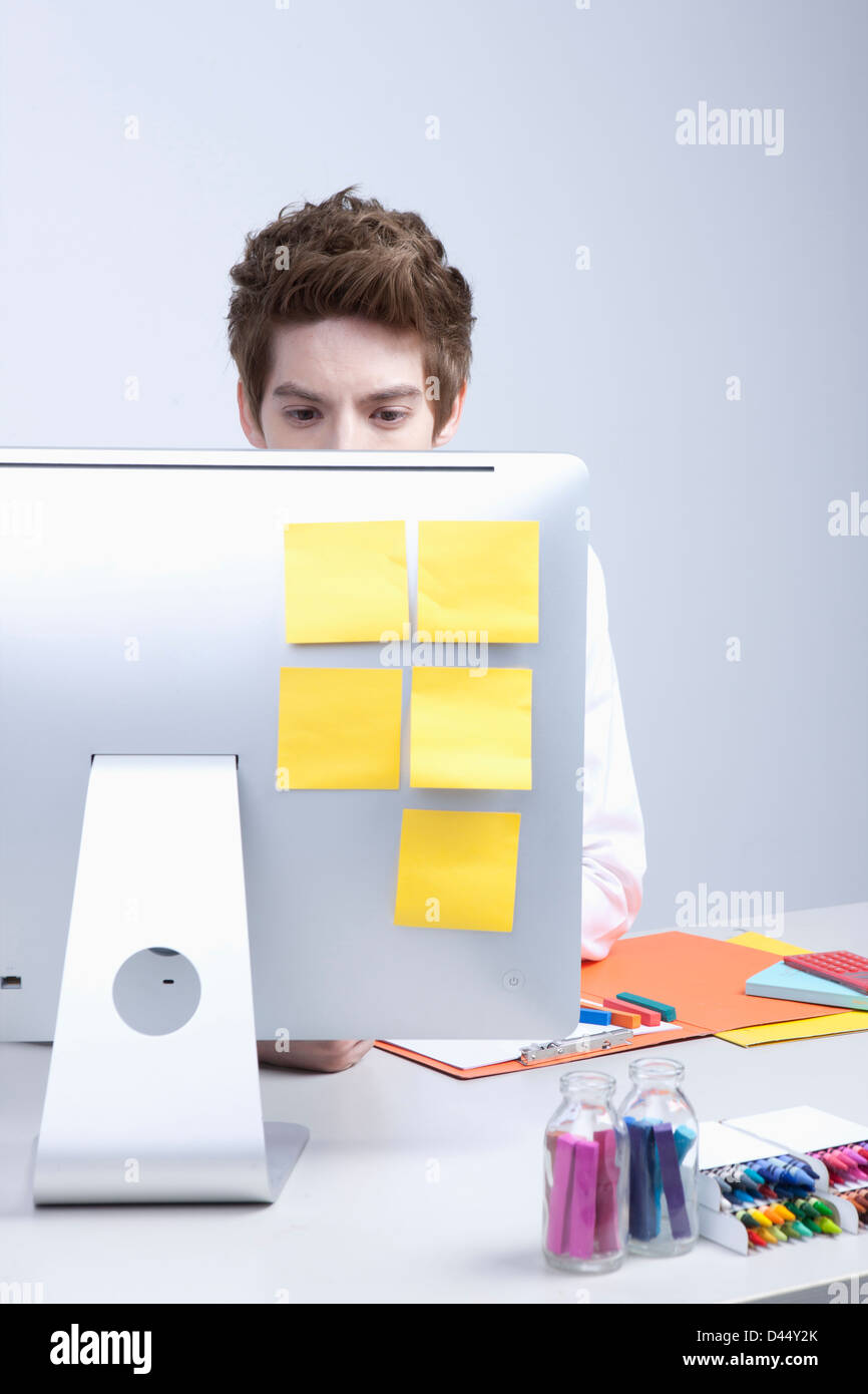 a man behind a computer on a desk Stock Photo - Alamy