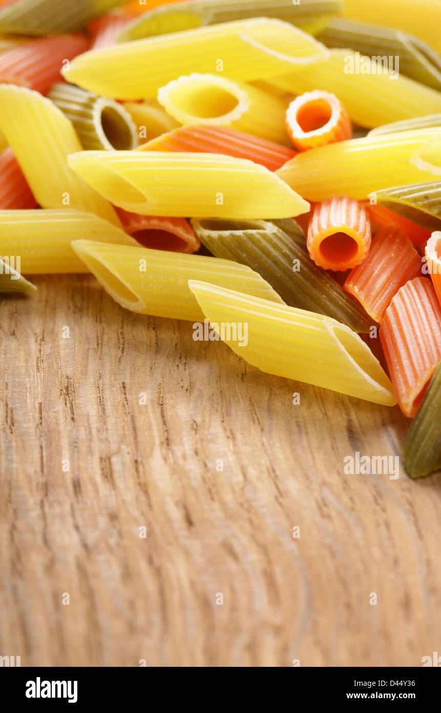 Pasta tricolor penne on the wooden table with copy-space Stock Photo ...
