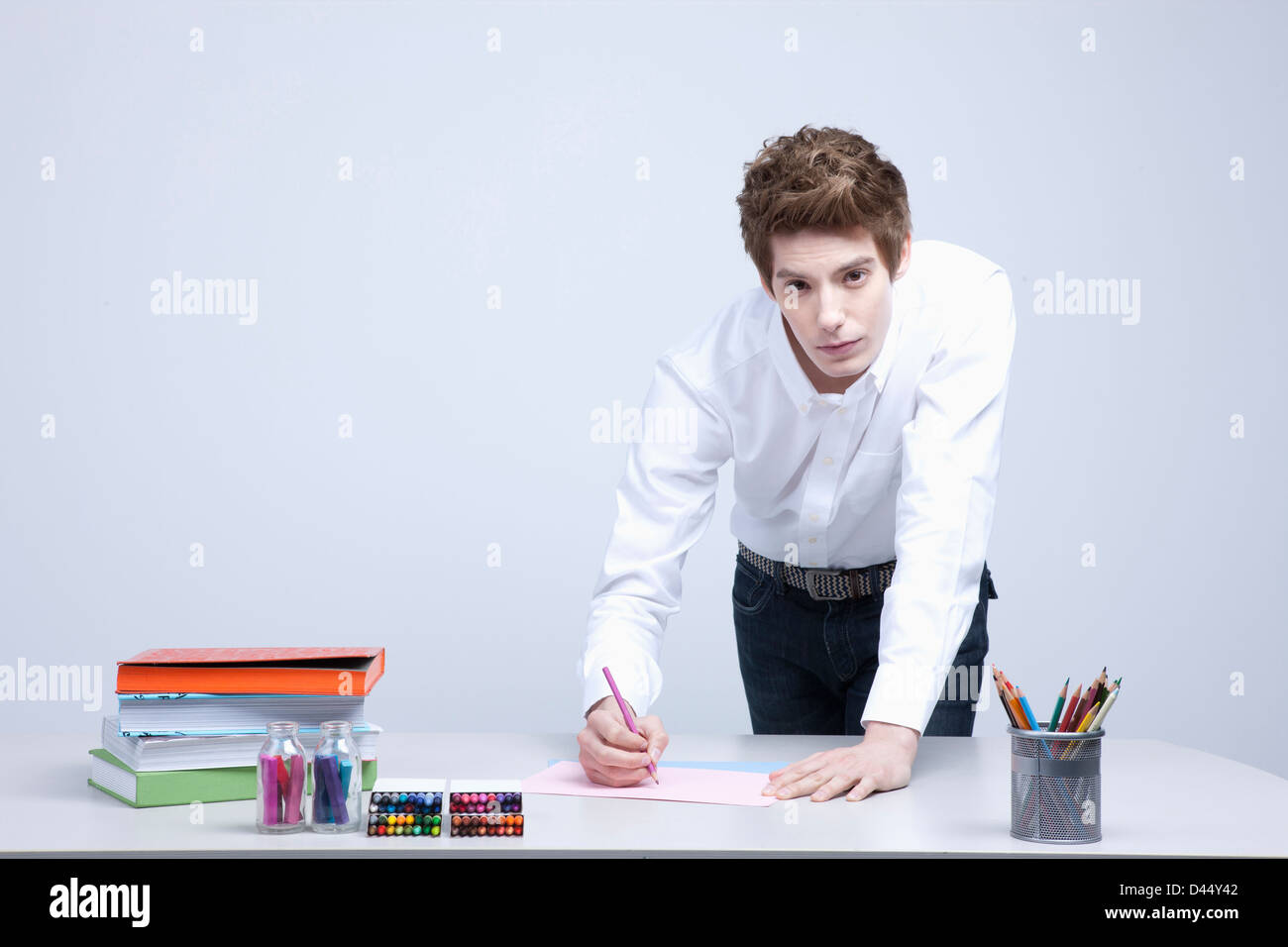 a man on a desk writing Stock Photo - Alamy