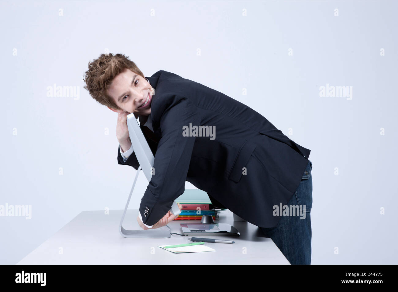 a man hugging a monitor on a desk Stock Photo - Alamy