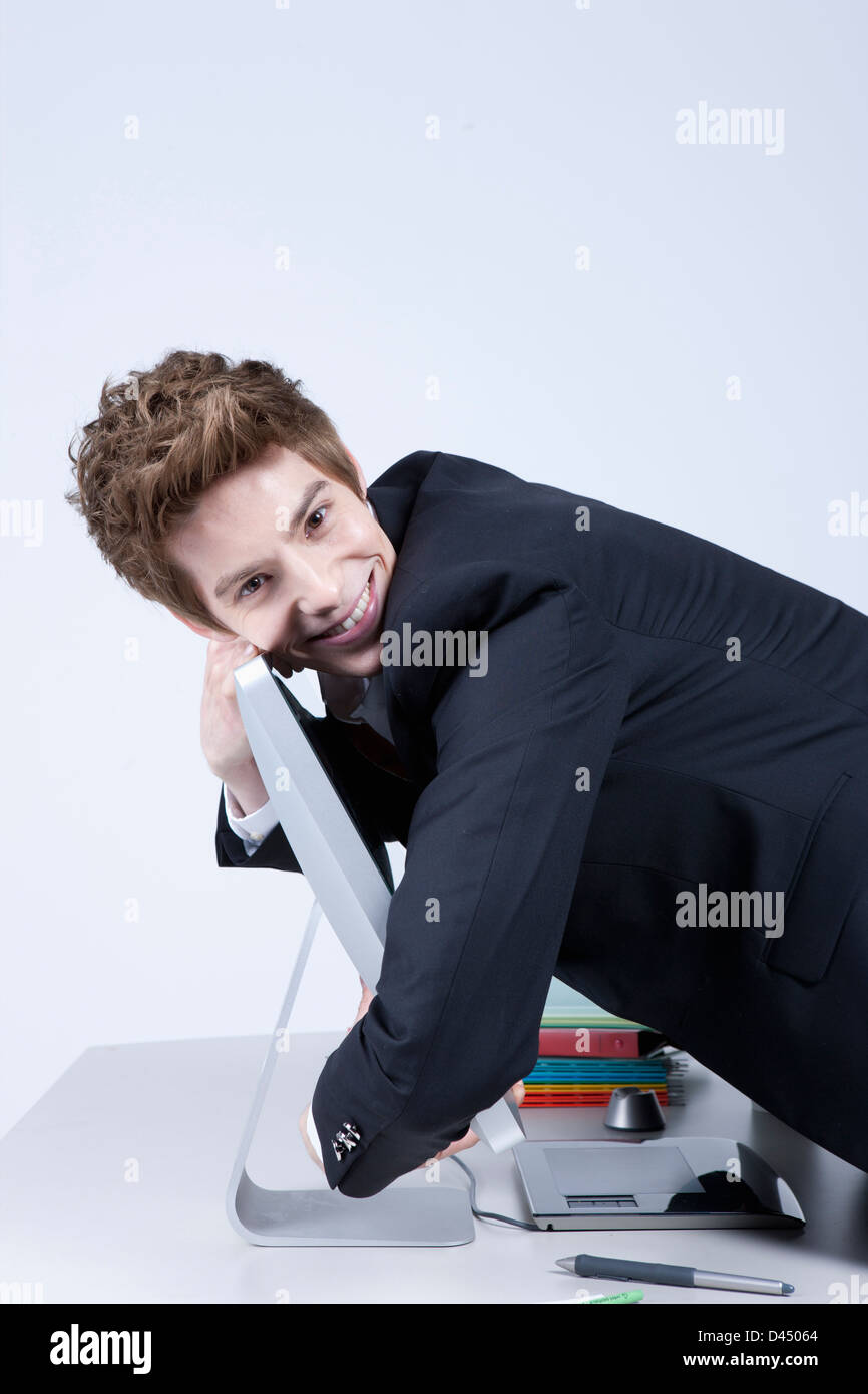 a man hugging a monitor on a desk Stock Photo - Alamy