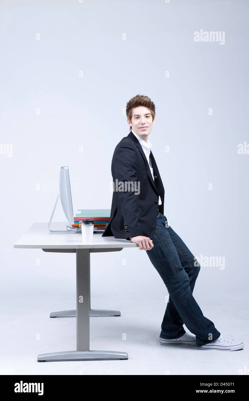 a man sitting on a desk Stock Photo - Alamy