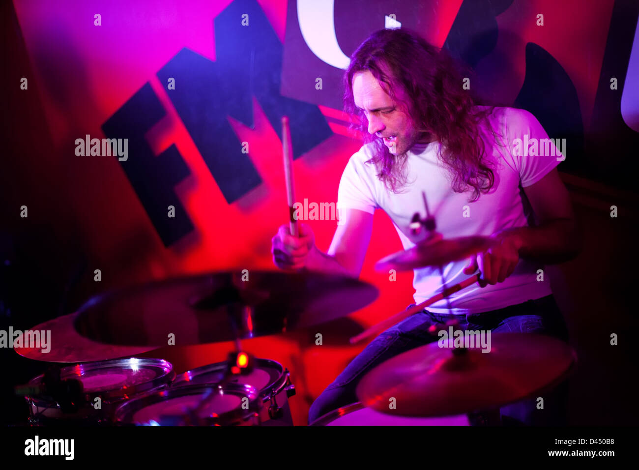 musician playing drums on a red background Stock Photo - Alamy