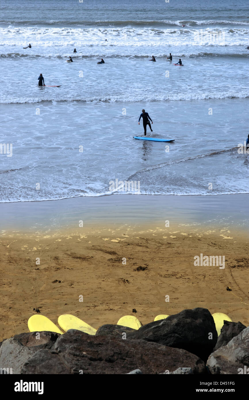 surfers wading out on the beach in lahinch county clare ireland on a ...