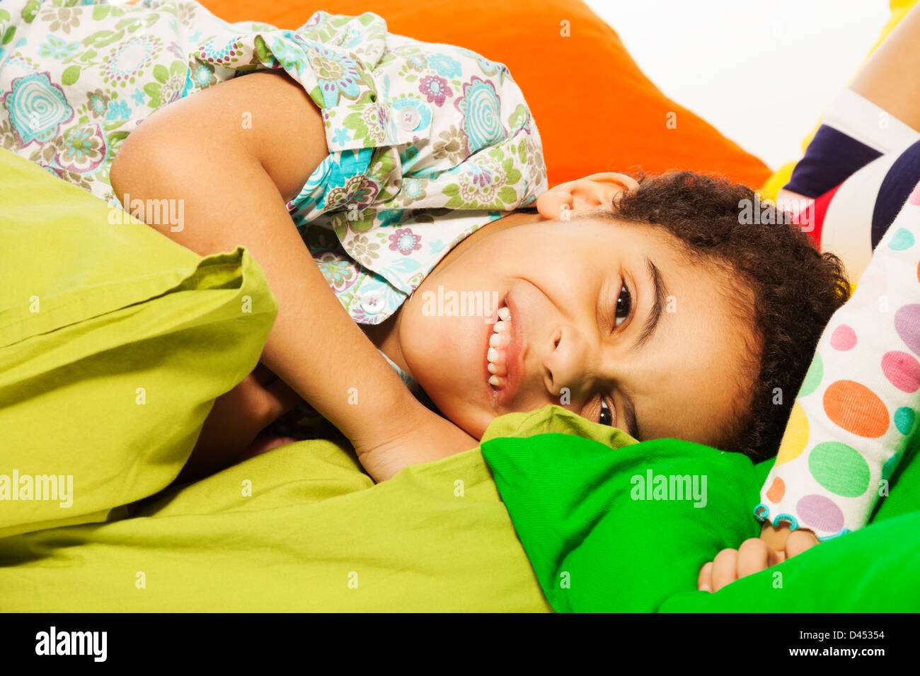 Happy black boy laying on the pillows with big smile Stock Photo - Alamy