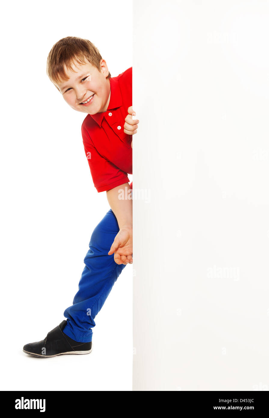 Handsome Caucasian boy, standing and smiling looking from behind white ...