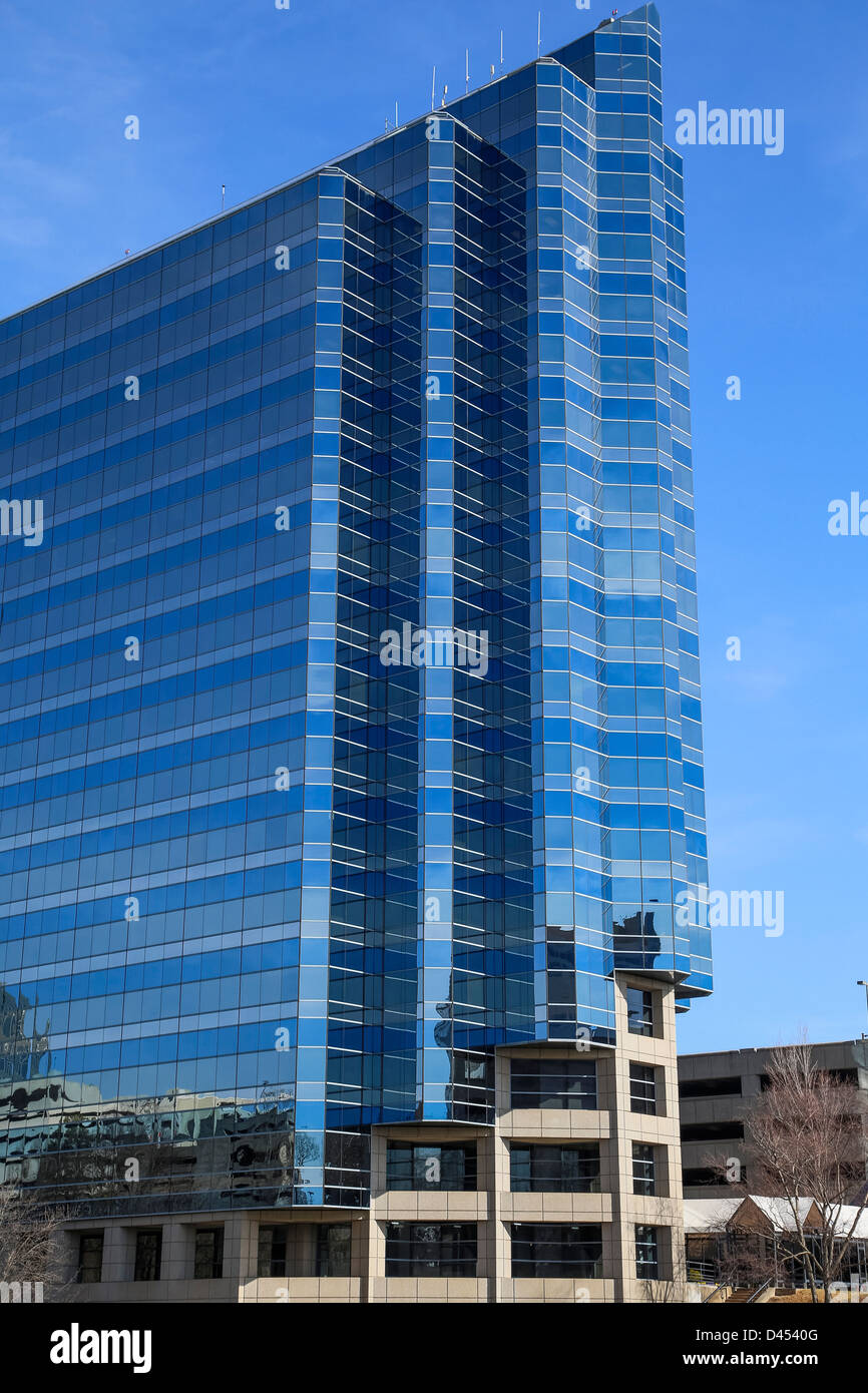 A modern blue glass office building iwth many angles on a clear blue ...
