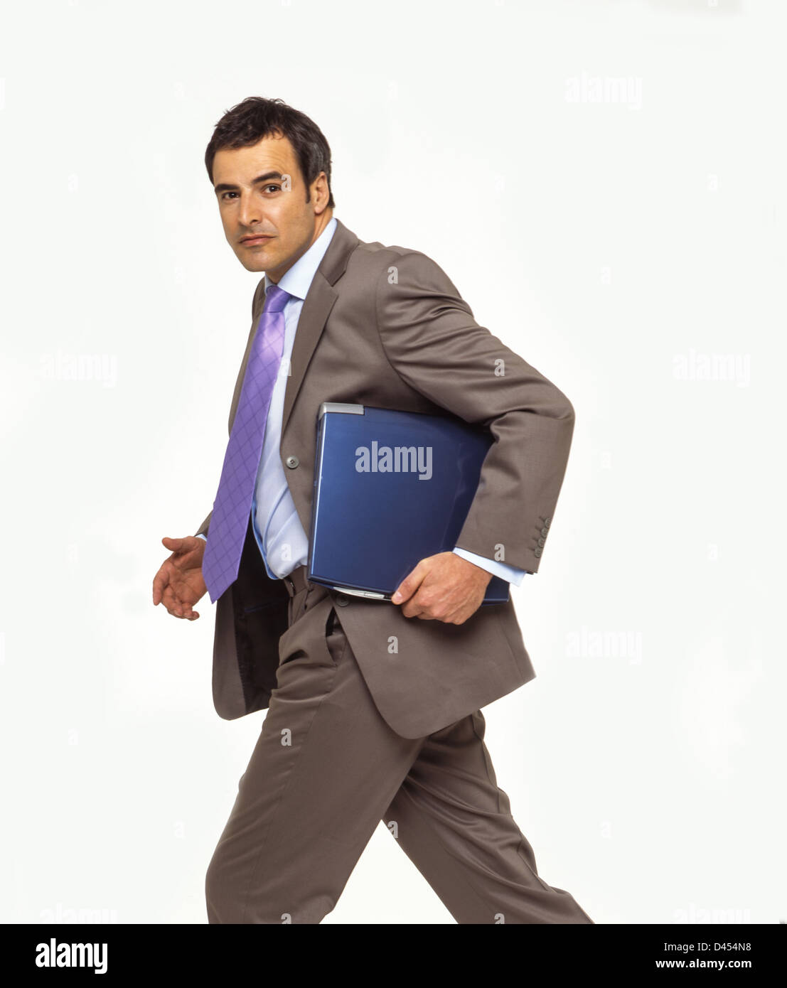 studio portraits of young handsome business man in a suit striding off ...