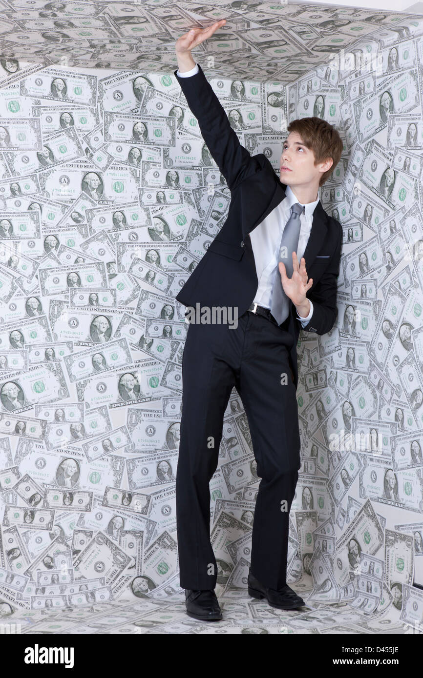 a businessman touching ceiling in a dollar room Stock Photo - Alamy