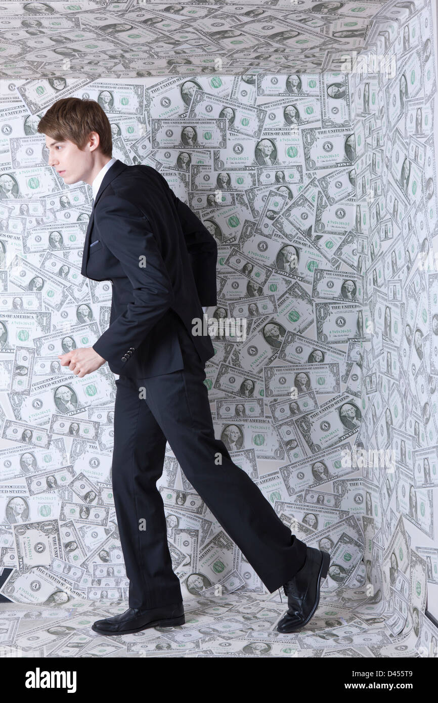 a businessman running away from a dollar room Stock Photo - Alamy
