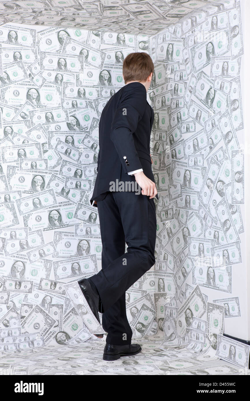a businessman running to a corner of a dollar room Stock Photo - Alamy