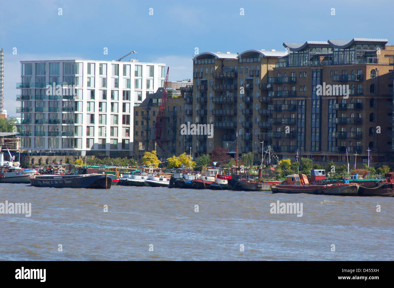 Waterfront apartments and boats moored on the Thames in London, England ...