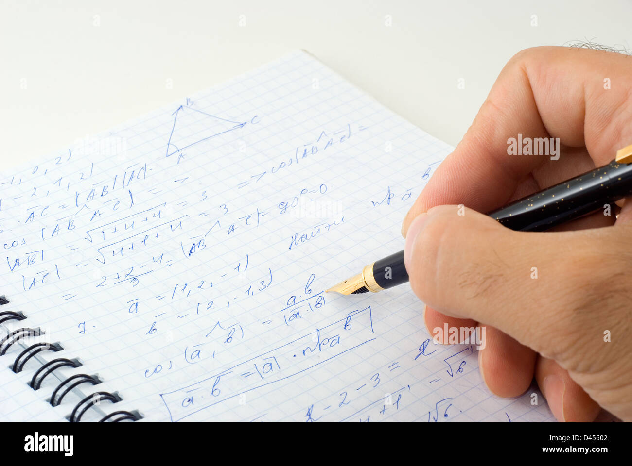 The hand with the pen writes formulas in a writing-book Stock Photo - Alamy