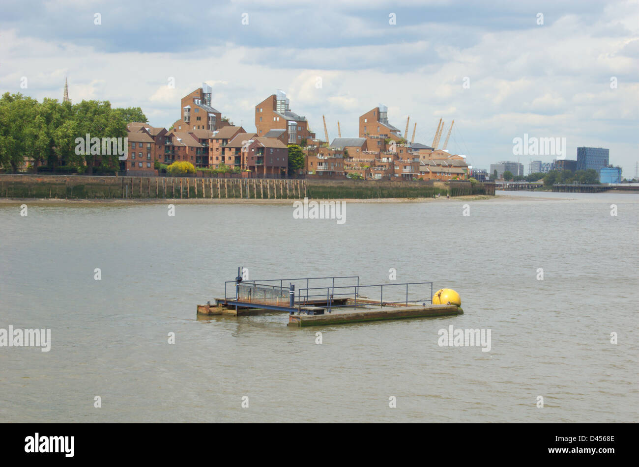 Waterfront flats and mooring platform on the River Thames in London ...