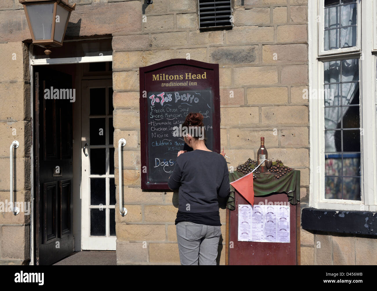 a woman writing the menu on a board outside the miltons hotel pub Stock ...