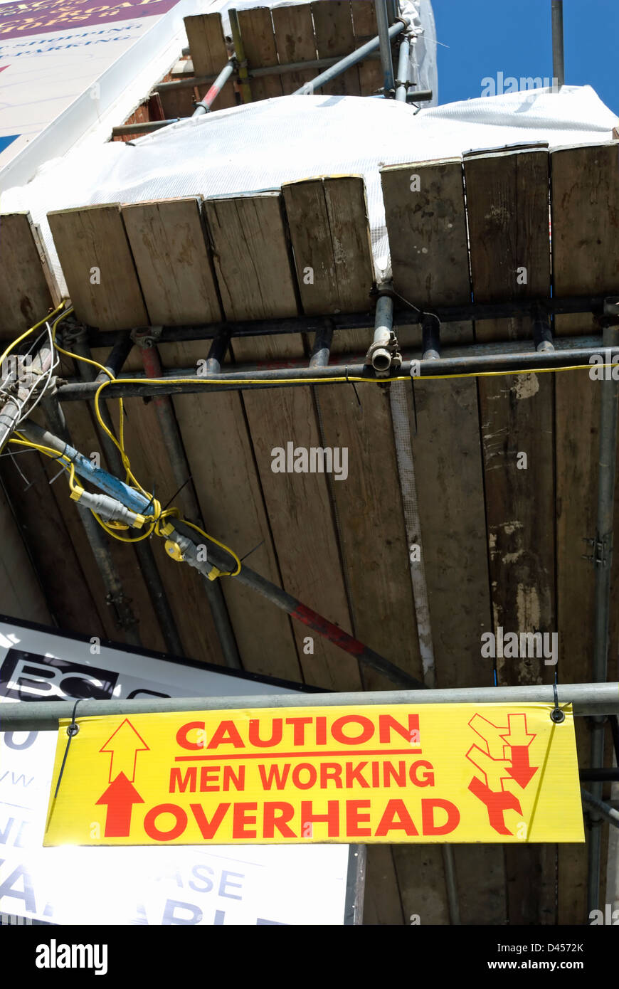 caution men working overhead sign at a building site in putney ...