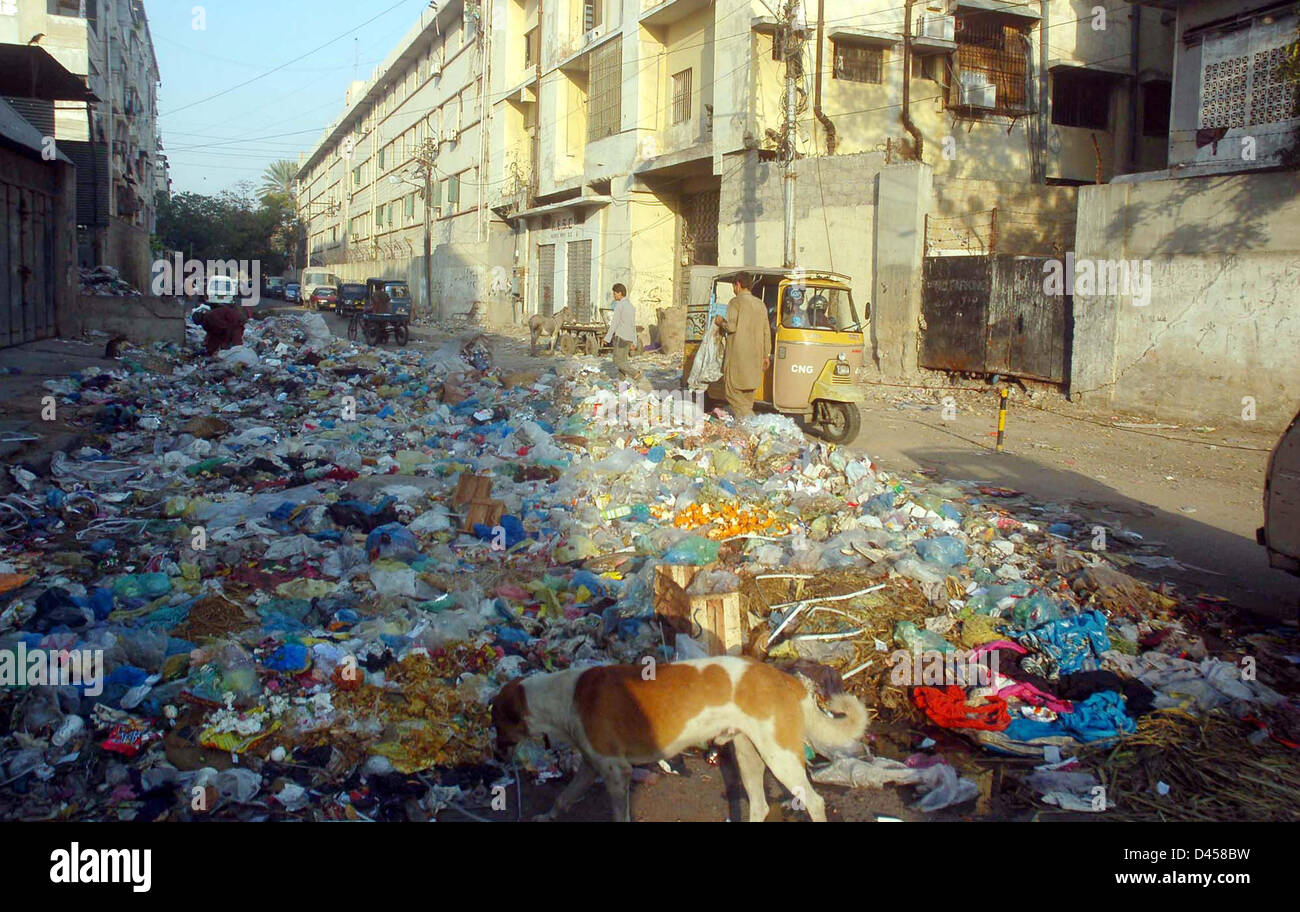 Karachi, Pakistan. 5th March 2013. Commuters pass through the huge heap ...