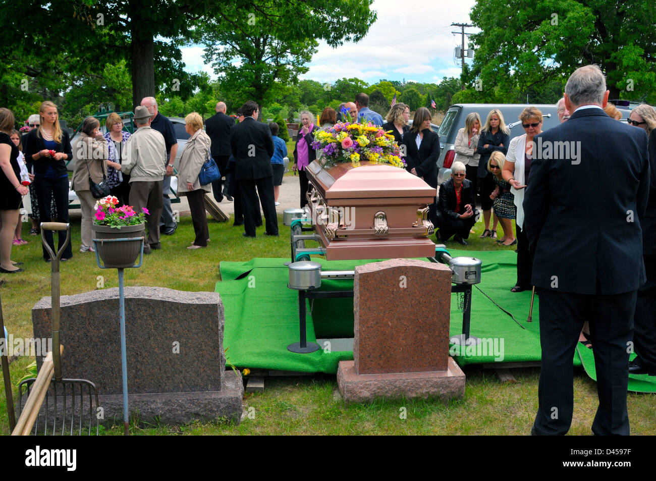 Funeral ending at cemetery gravesite with mourners and pallbearers ...