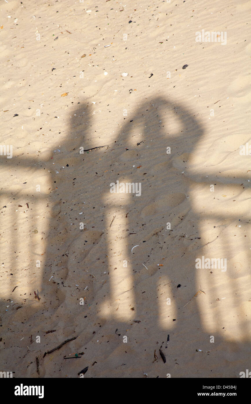 Shadow of two people by railings on the sand at Bournemouth beach in ...
