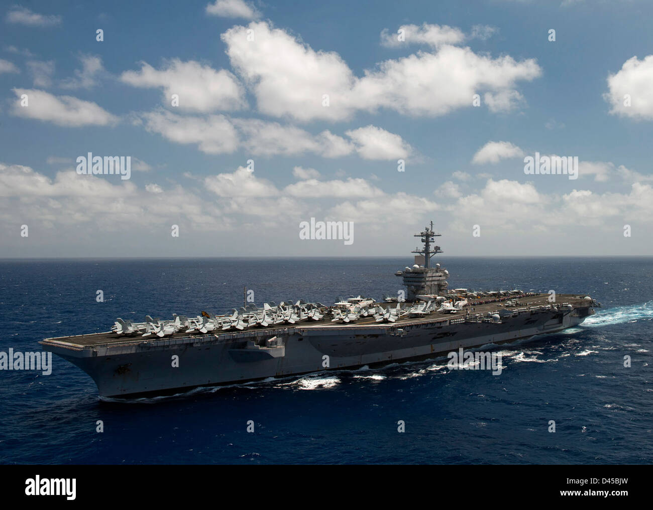 Participants of a Tiger Cruise aboard a U.S. Navy ship gather to spell ...