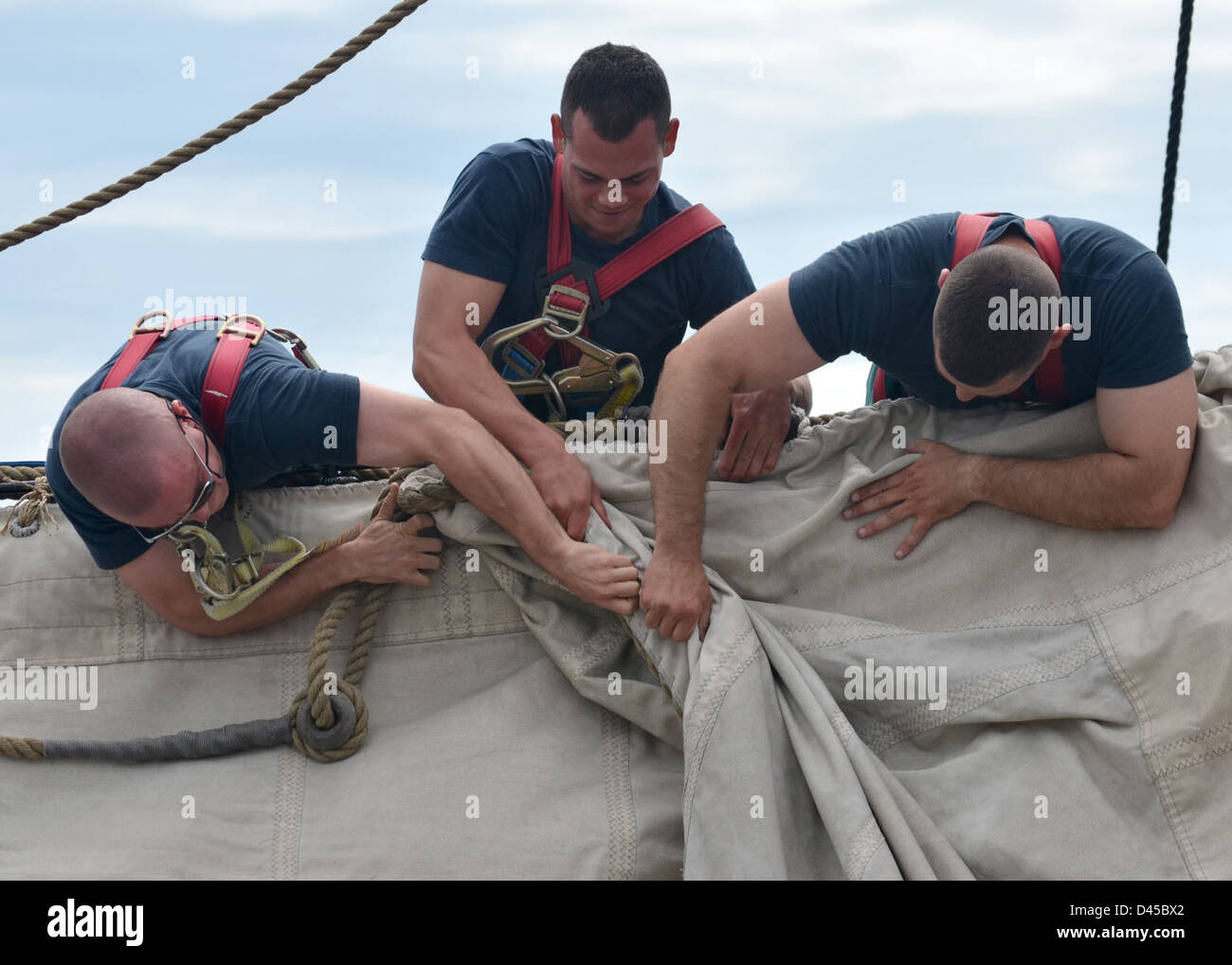 Sailors aboard the USS Constitution handle the topsail during routine ...