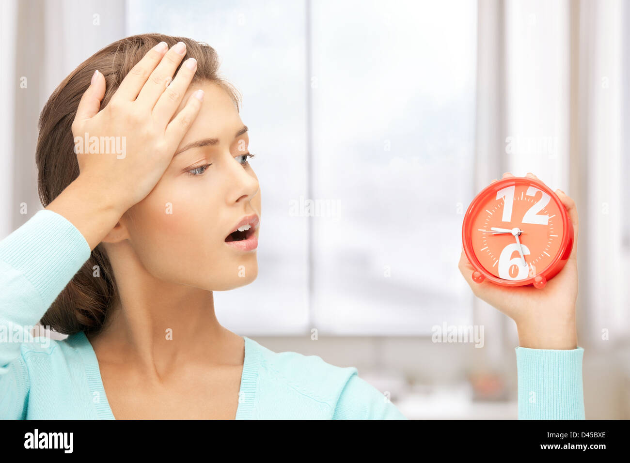 woman holding alarm clock Stock Photo - Alamy